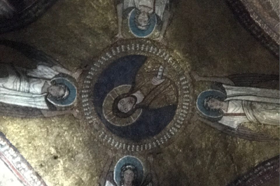 Teto com frescos elaborados e detalhes arquitetônicos.