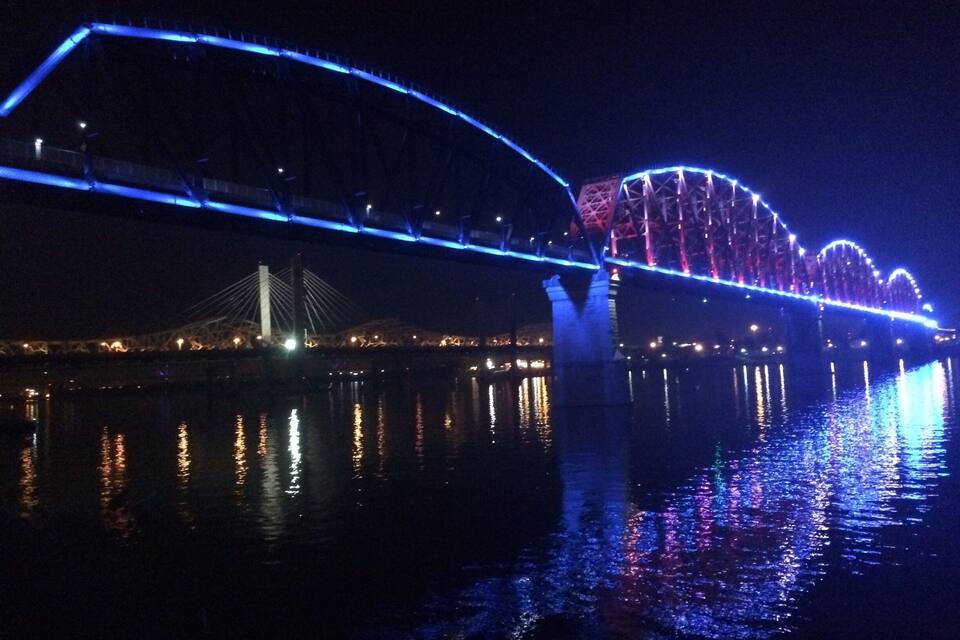 Uma ponte com luzes azuis iluminadas à noite.
