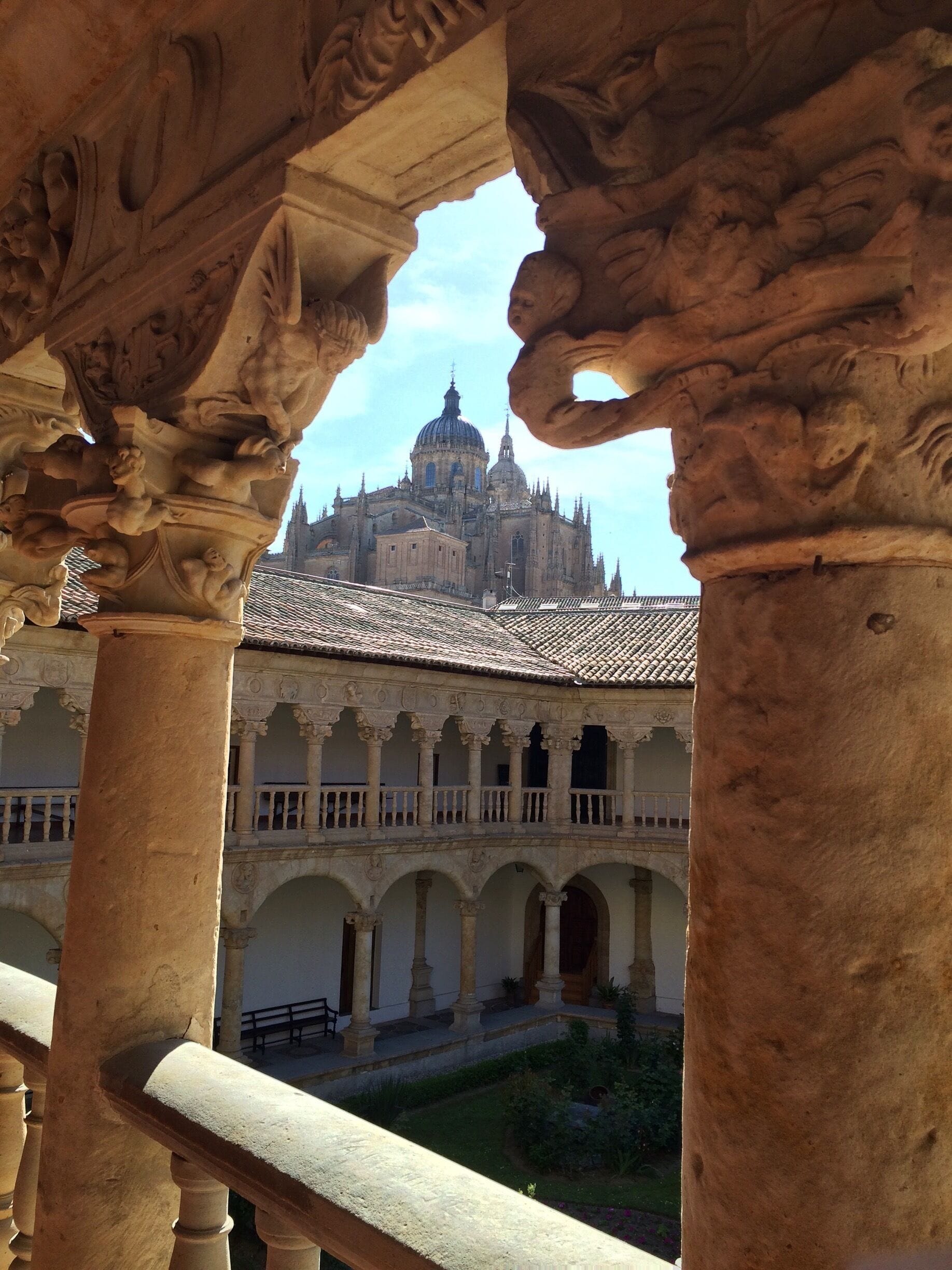 Vista de um edifício histórico com elaborados entalhes em pedra e um pátio.