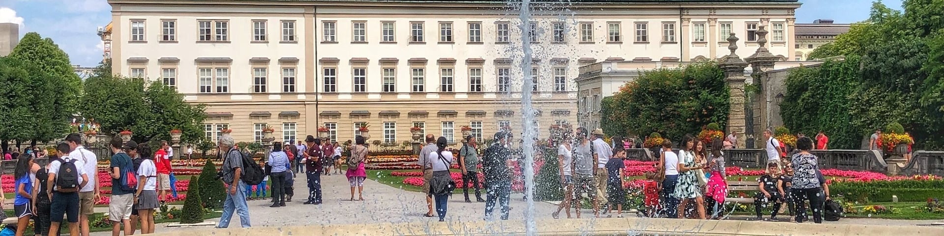 Um edifício histórico com uma fonte em primeiro plano.