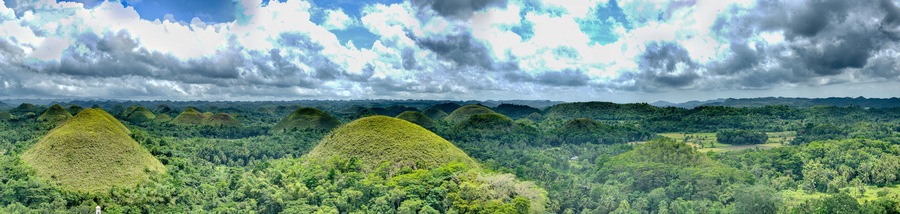 Paisagem com colinas onduladas e florestas densas.