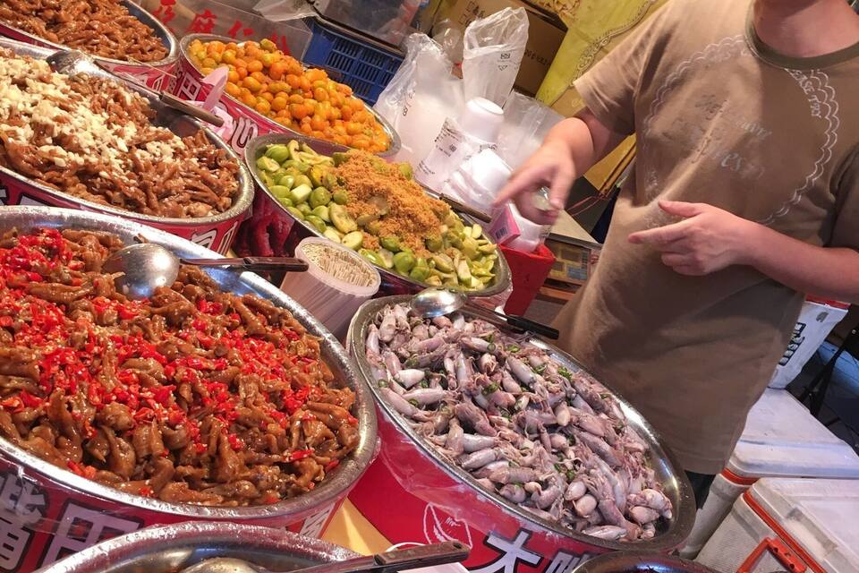 Um quiosque de comida com diversos pratos expostos em recipientes de metal.