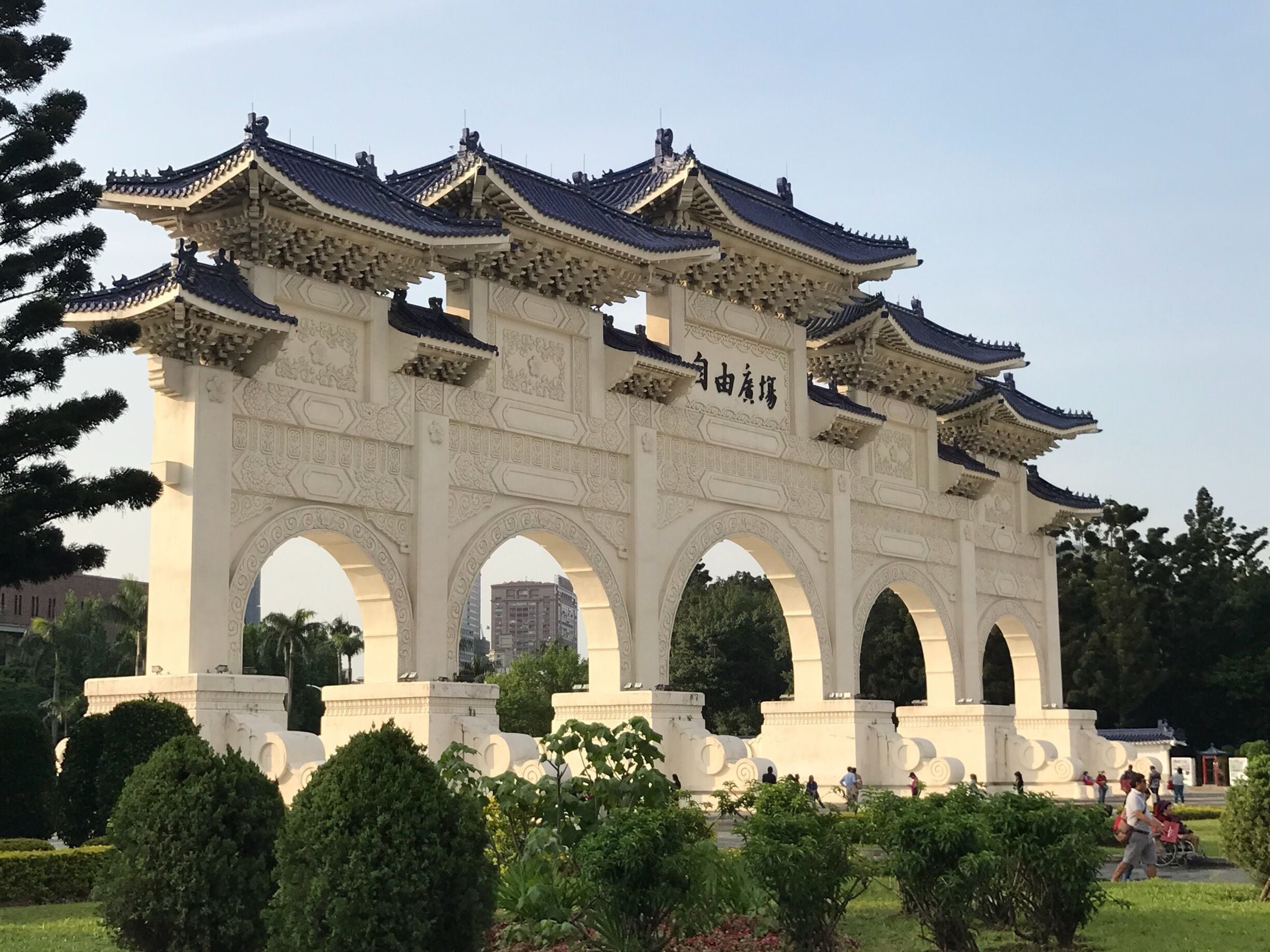 Um portão chinês tradicional com esculturas elaboradas e múltiplas abóbadas.