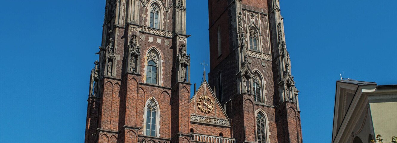 Uma igreja grande e histórica, com duas torres altas e detalhes arquitetônicos elaborados.