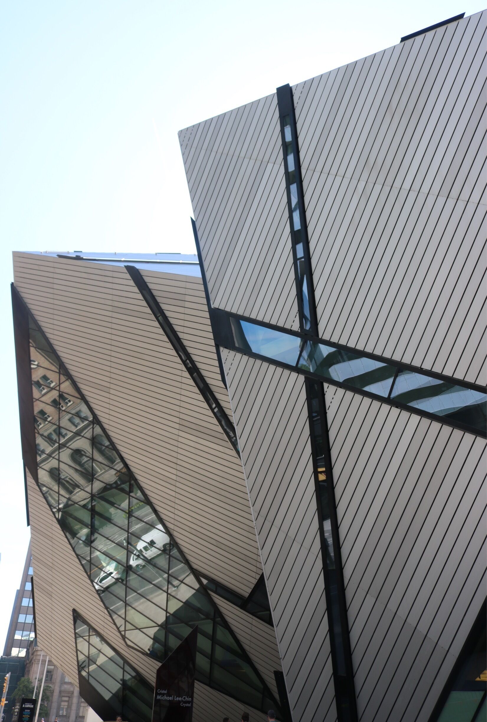 Um edifício moderno com design angular e fachada de vidro refletivo.
