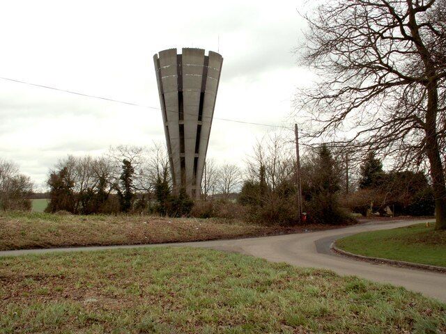 Uma estrutura alta e moderna, semelhante a uma torre, em área rural, com uma estrada sinuosa e árvores sem folhas.