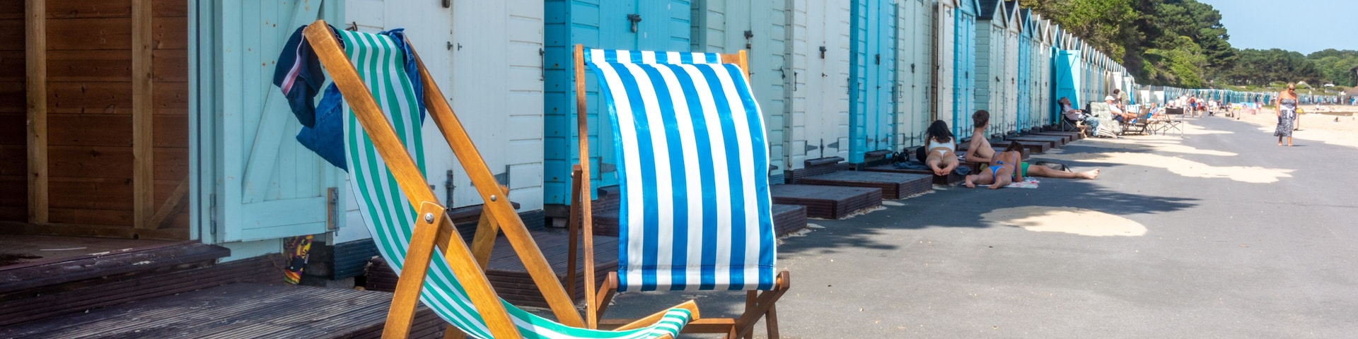 Fileira de cabanas de praia com cadeiras de praia listradas na frente.