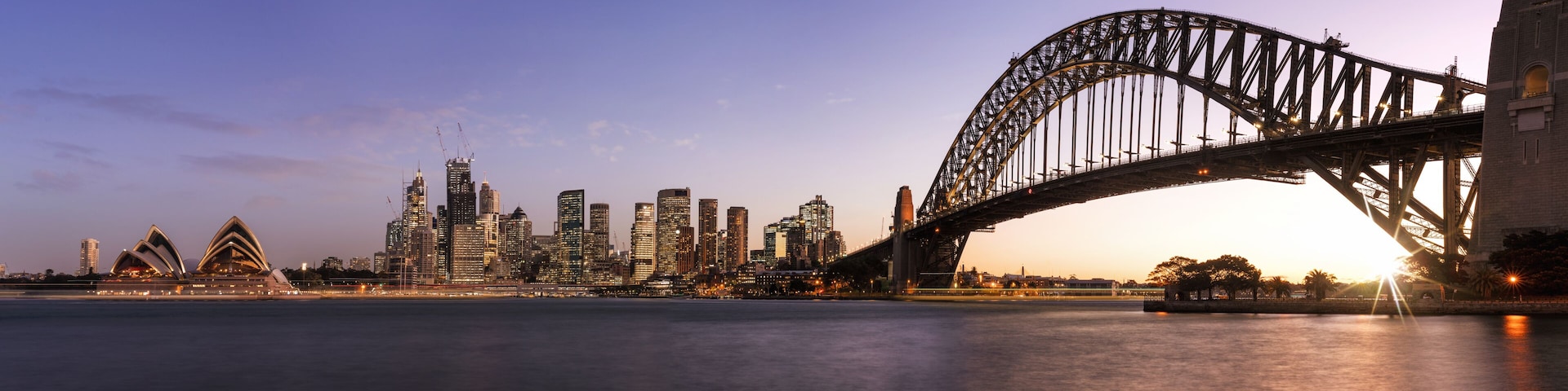 A Casa da Ópera de Sydney e a Ponte Sydney Harbour ao entardecer.