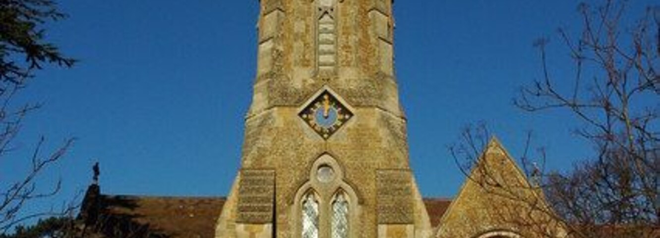 Igreja com uma torre alta e pontiaguda e entrada em arco.