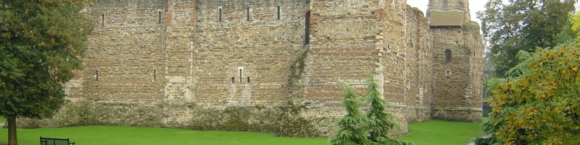 Um castelo de pedra histórico com um jardim bem cuidado e um caminho.