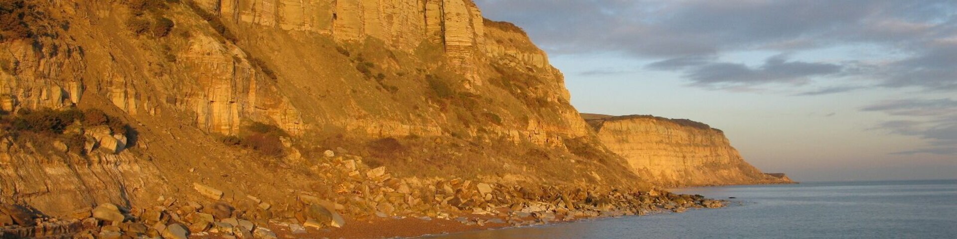 Um penhasco costeiro com costa rochosa e mar calmo.