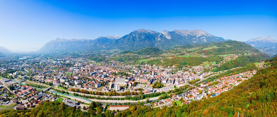 Vista panorâmica de uma cidade situada num vale, com montanhas ao fundo.
