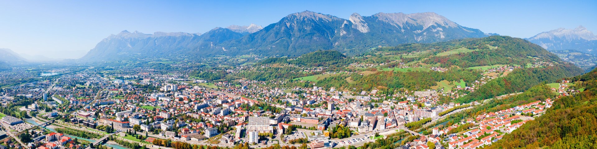 Vista panorâmica de uma cidade situada num vale, com montanhas ao fundo.