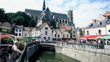Uma cidade histórica com uma catedral imponente, ruas estreitas e um canal.