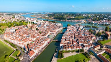 Vista panorâmica de uma cidade histórica, com rio, pontes e uma catedral imponente.