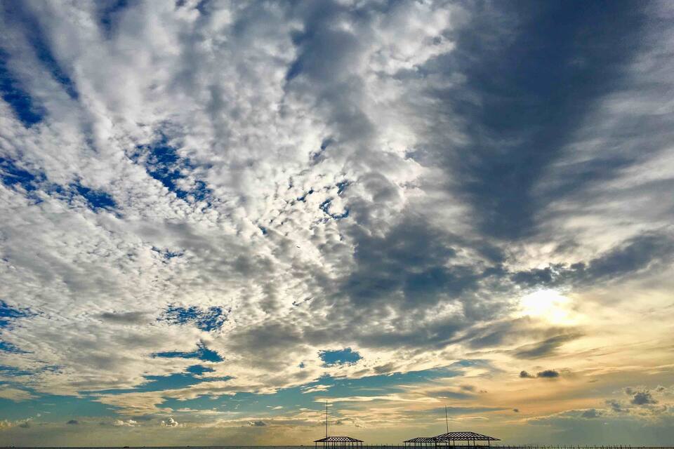Um cais se estendendo na água sob um céu nublado.