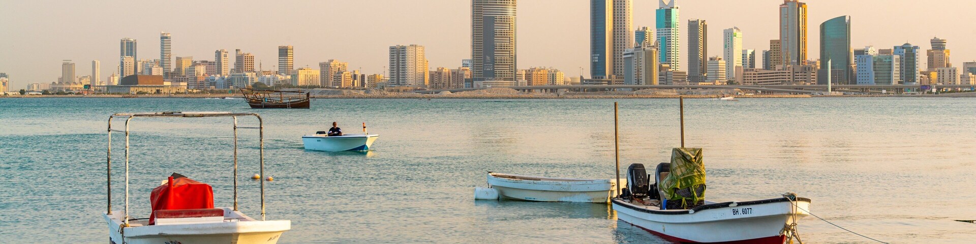 Paisagem costeira com barcos ancorados perto da praia.