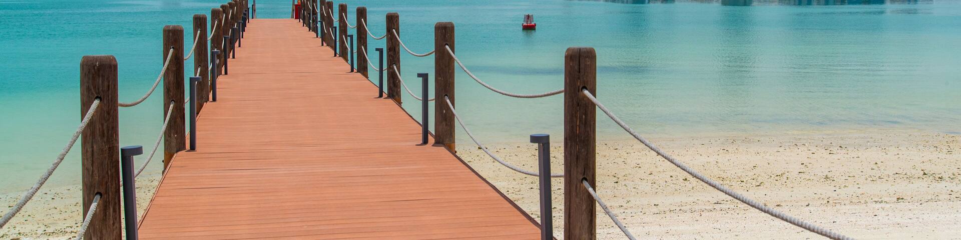 Manama which includes general coastal views, a city and a sandy beach