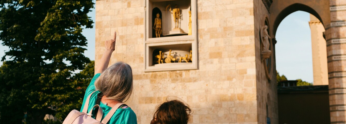 Uma torre histórica com estátuas e um grande arco.
