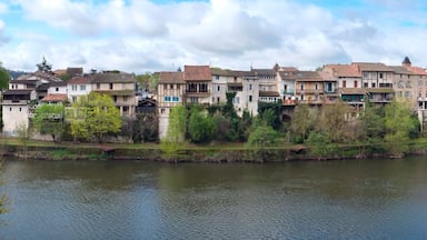 Uma cidade às margens do rio, com edifícios históricos e uma ponte.