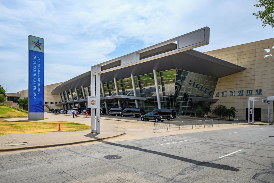 Centro de convenções moderno, com um grande letreiro azul e design arquitetônico marcante.