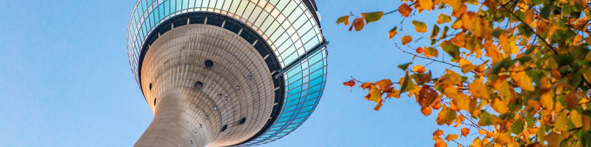 Uma torre com cúpula de vidro e antena vermelha e branca.