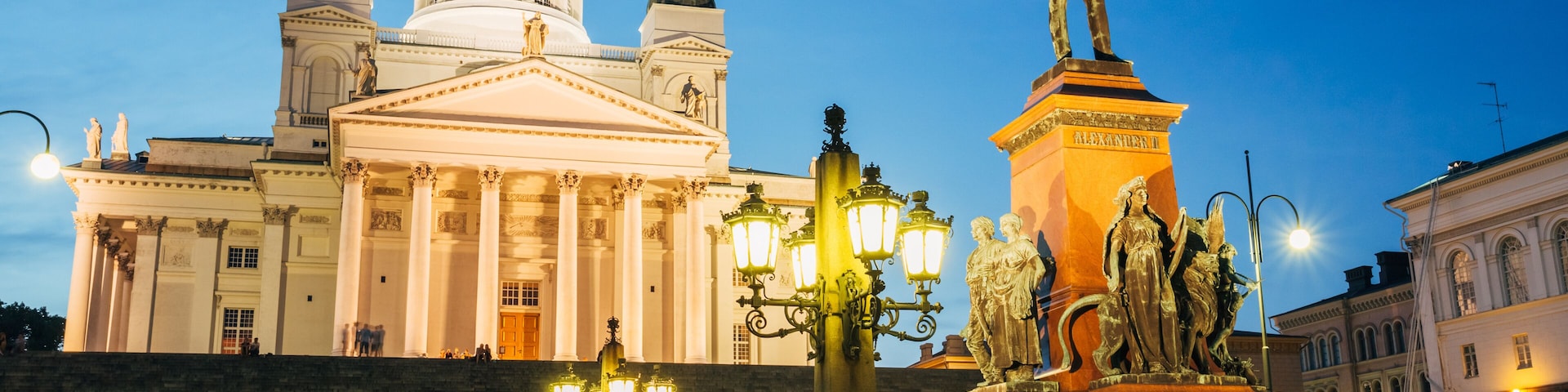 Um edifício histórico com arquitetura em cúpula e uma estátua de uma figura em um pedestal.