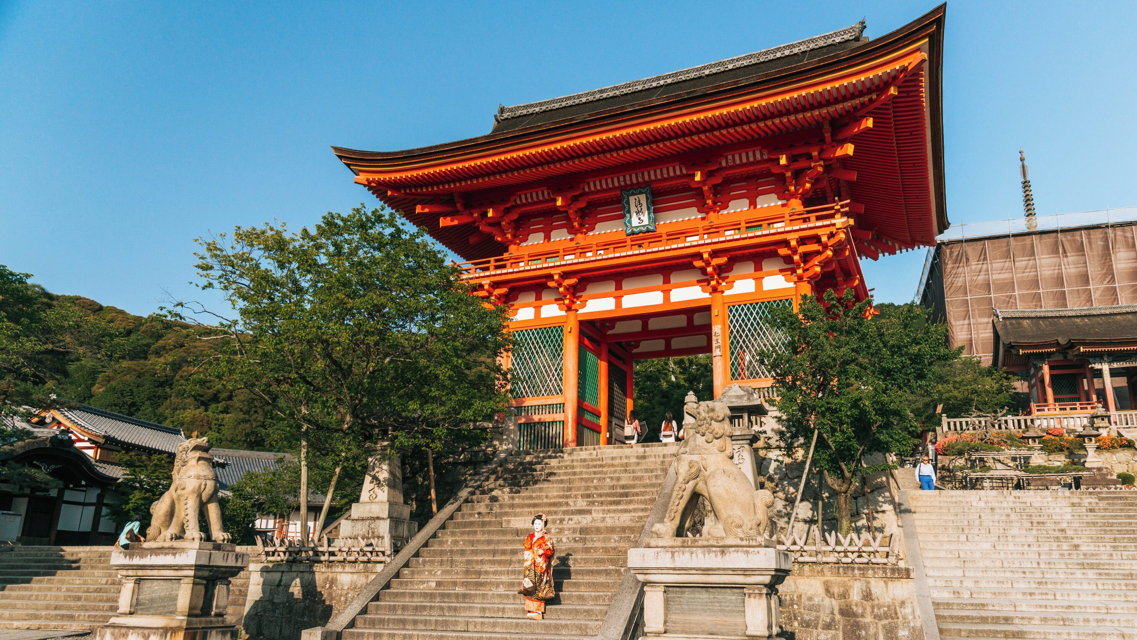 Kiyomizu Temple in Higashiyama Ward, Kyoto, Japan showcases intricate architecture against a clear blue sky in mid-afternoon light