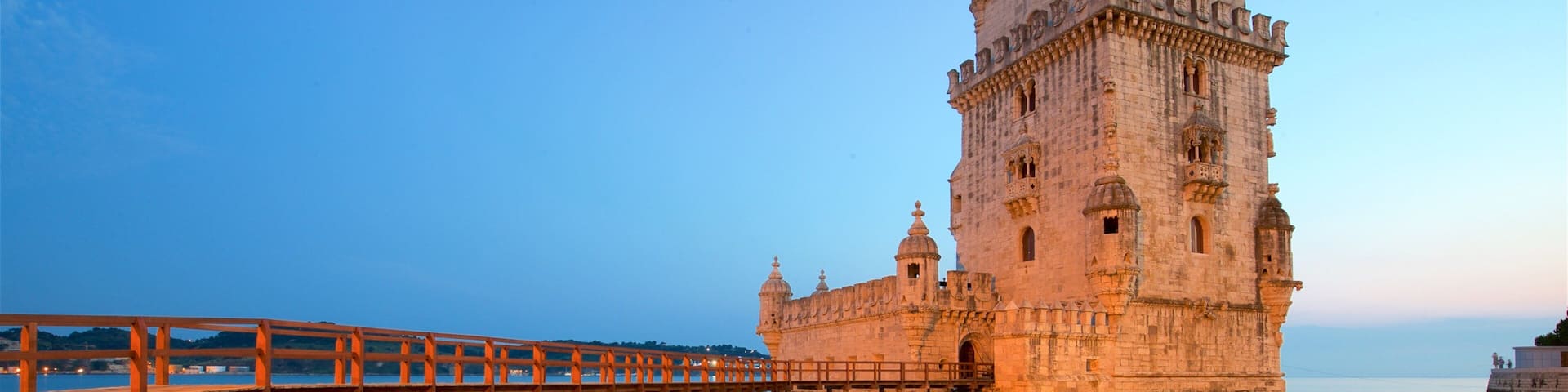 Torre de Belém caracterizando arquitetura de patrimônio, um lago ou charco e um pôr do sol