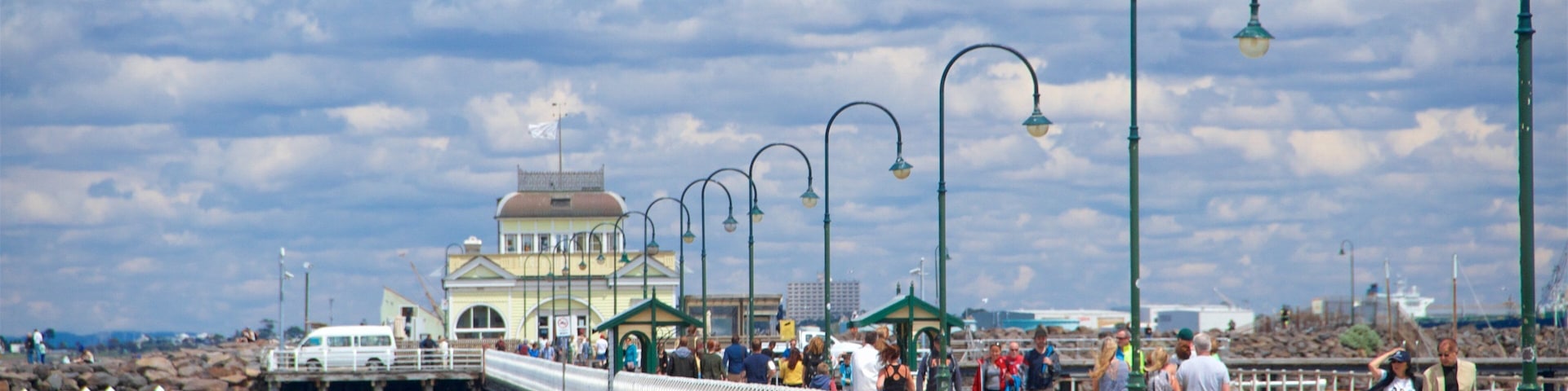 St Kilda Pier featuring heritage elements and a bay or harbor as well as a small group of people