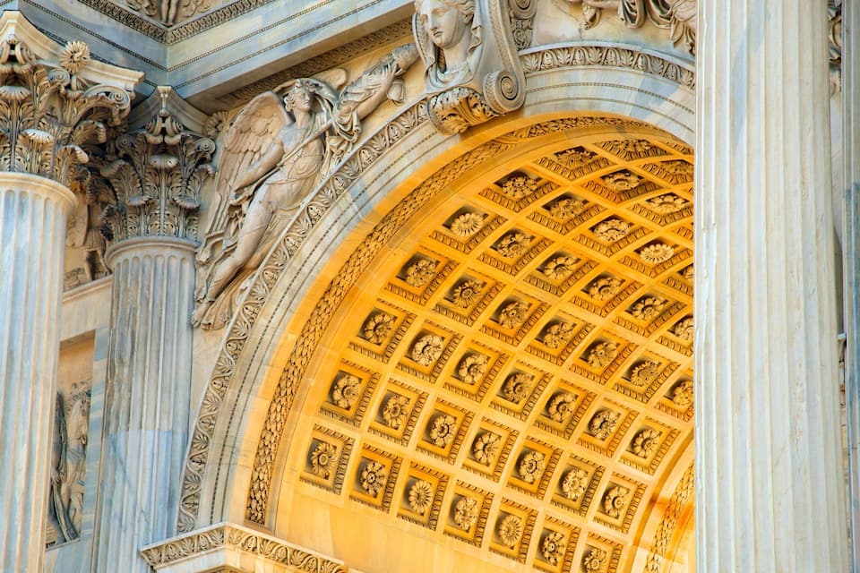 Fachada arquitetônica detalhada com esculturas elaboradas e teto trabalhado.