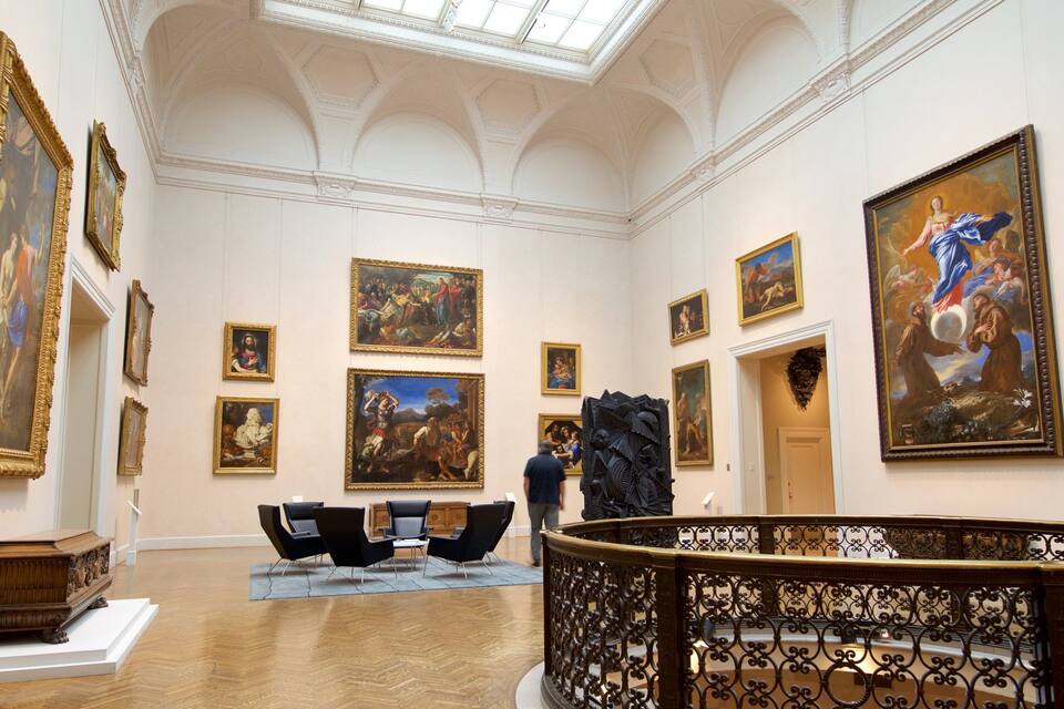 Uma galeria de arte imponente com pinturas e esculturas clássicas.