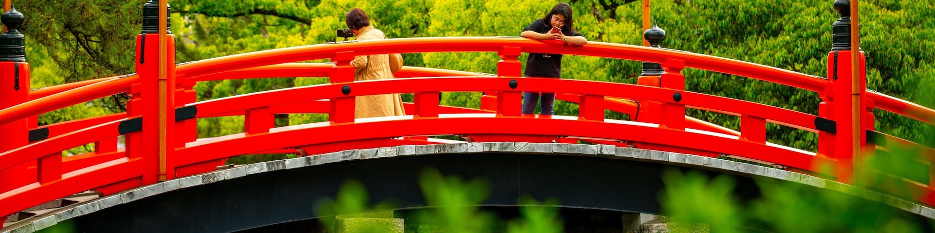 Sumiyoshi Taisha Shrine showing a bridge as well as an individual femail