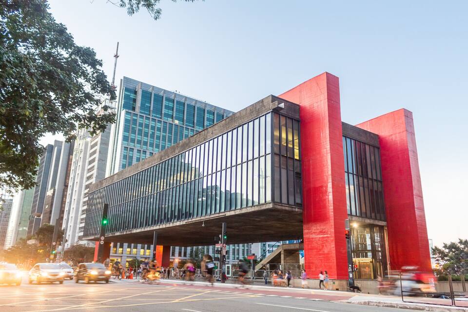 Um edifício moderno com fachada vermelha e extensão de vidro.