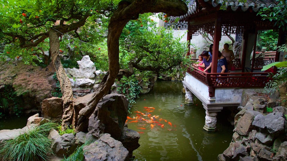 Yu Yuan Garden featuring a pond and a garden as well as a small group of people