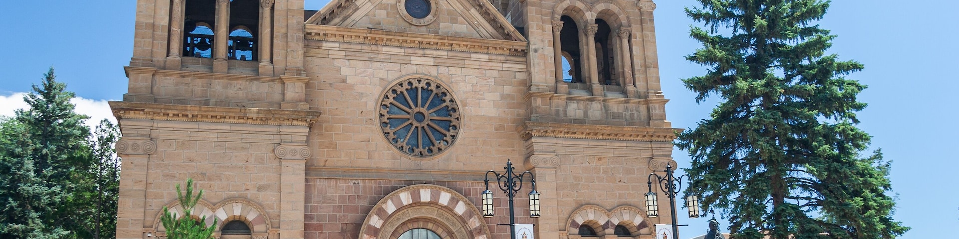 Uma igreja histórica com uma grande janela circular e duas torres de sino.