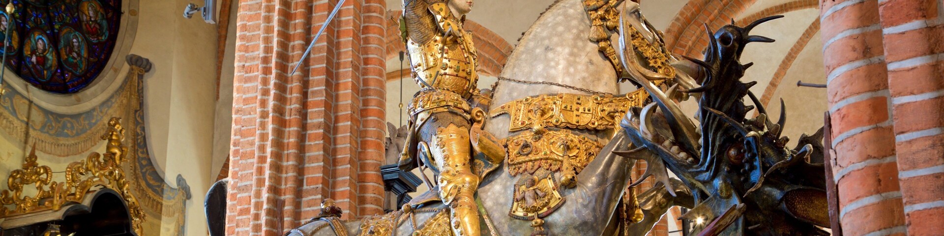 Estátua dourada de um cavaleiro a cavalo em uma catedral.