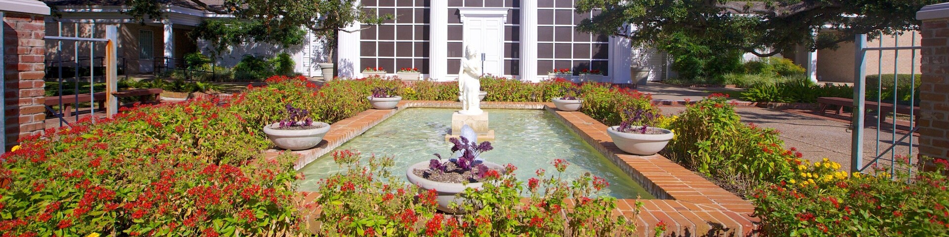 O Houston Garden Center, com uma fonte central, rodeado por canteiros de flores vibrantes e um jardim bem cuidado.