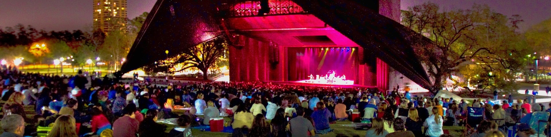 Crowd enjoying a live performance at Hermann Park's outdoor theater in Houston, Texas during a vibrant evening event