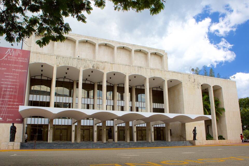 Um edifício grande com uma entrada em arco notável e um banner no lado esquerdo.