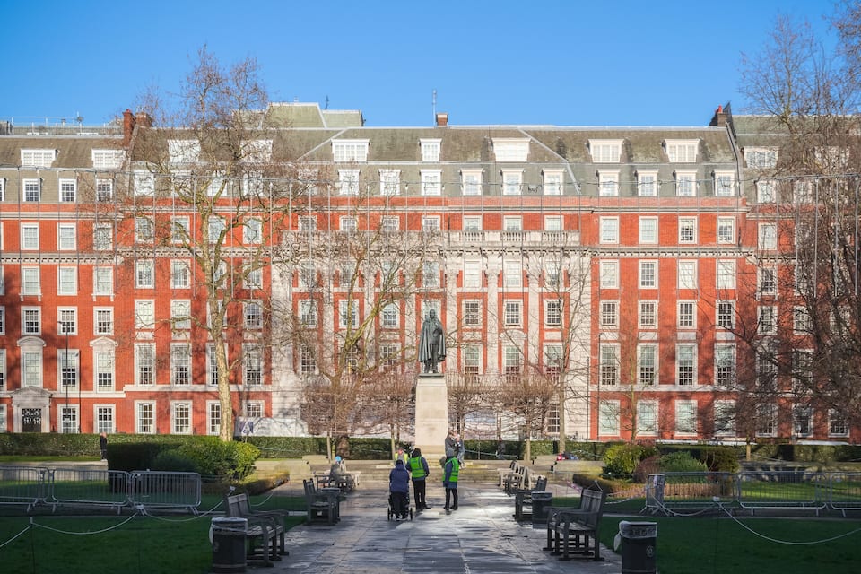 Um edifício de tijolos vermelhos com uma estátua em frente.