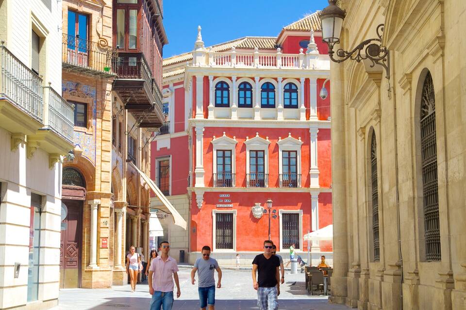 Rua com edifícios coloridos, incluindo um vermelho com a inscrição 'Plaza de San Francisco'.
