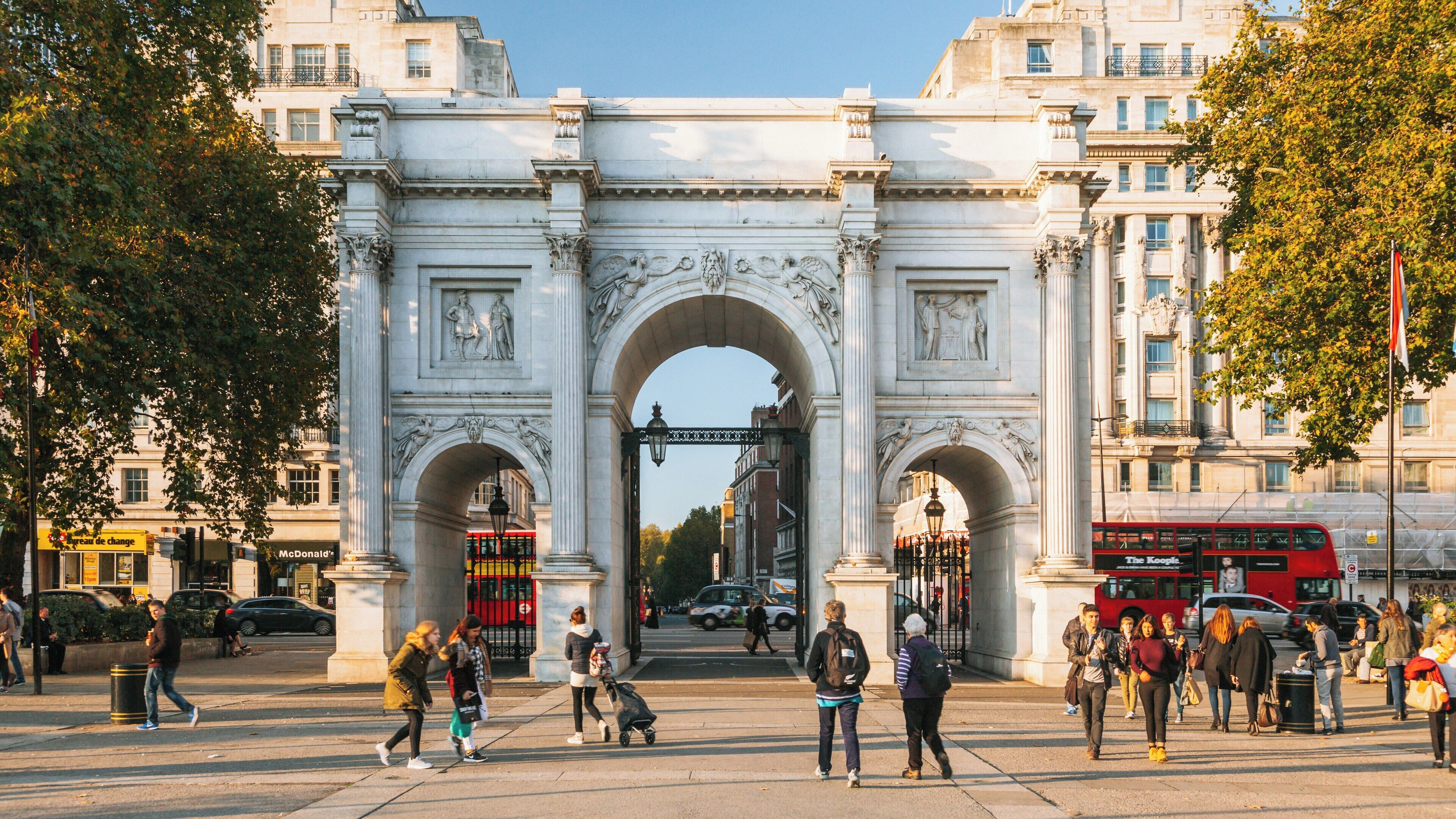 Iconic Marble Arch in City of Westminster, London showcases vibrant daily life under clear blue skies