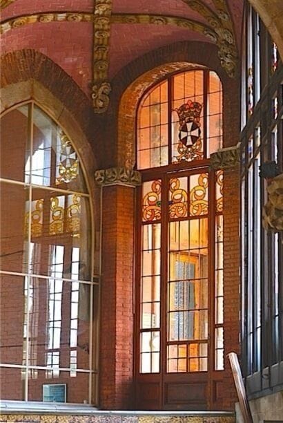 Um edifício com janelas em arco e uma porta decorativa com vitrais.