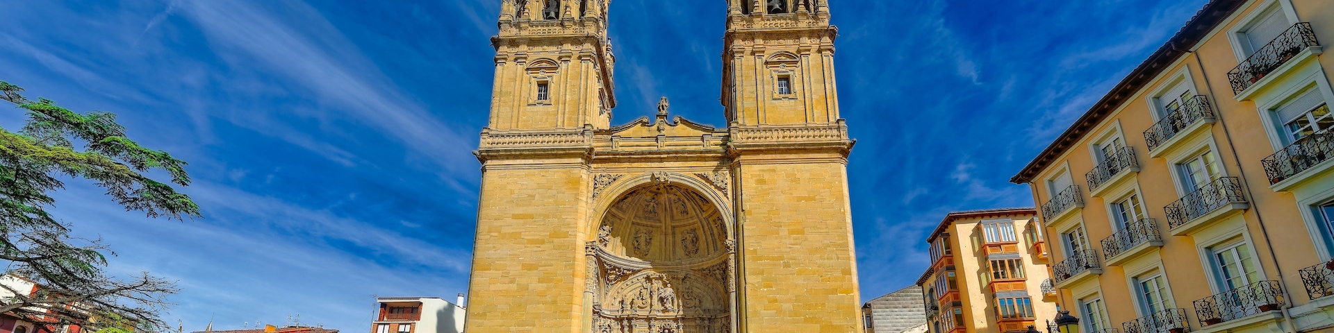Uma catedral histórica com duas torres e fachada ricamente decorada.