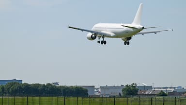 Avião pousando, com o trem de pouso estendido, aproximando-se da pista.