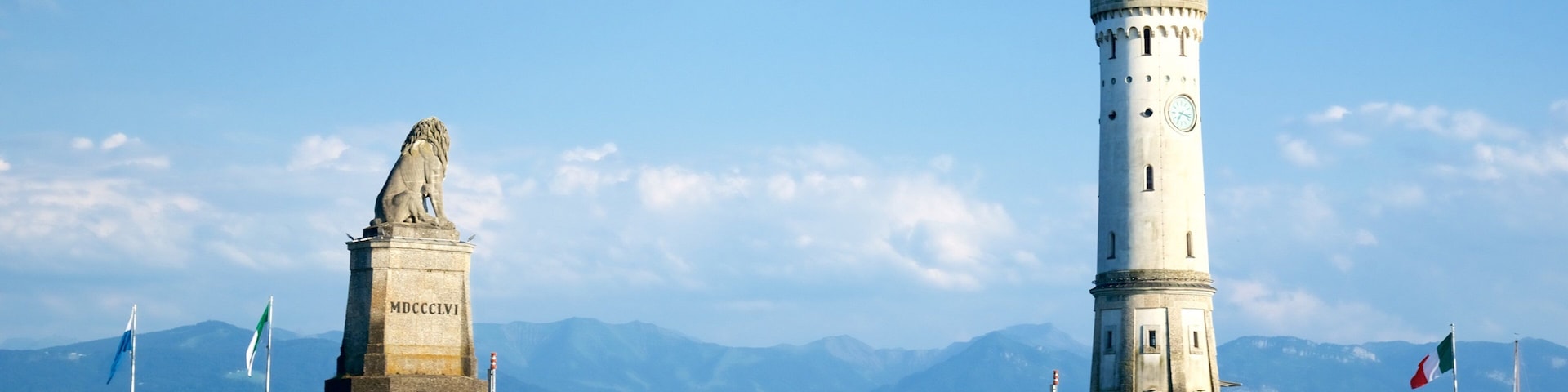 Lindau que inclui uma estátua ou escultura, montanhas e um farol