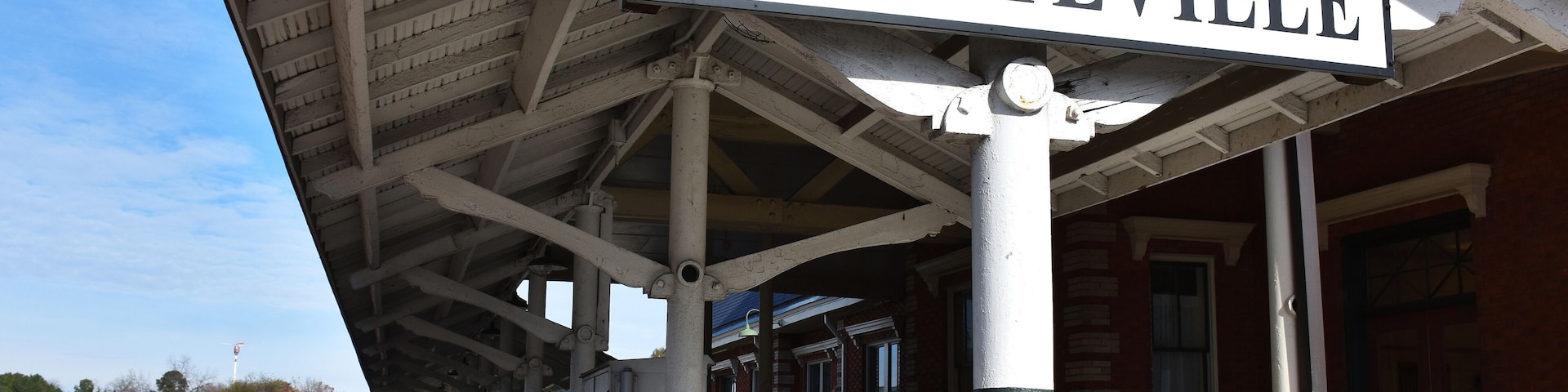 Plataforma de estação de trem com uma placa indicando