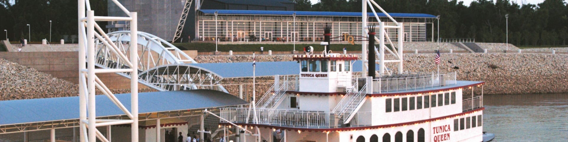 Tunica mostrando uma cidade litorânea e uma balsa