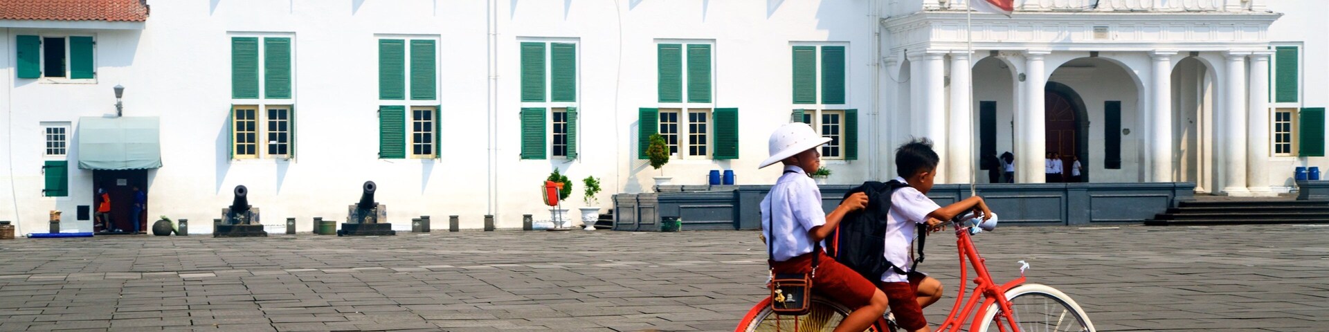 Old Jakarta showing road cycling and a square or plaza as well as children